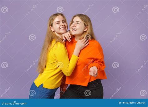 Two Cheerful Young Blonde Twins Sisters Girls In Vivid Colorful Clothes