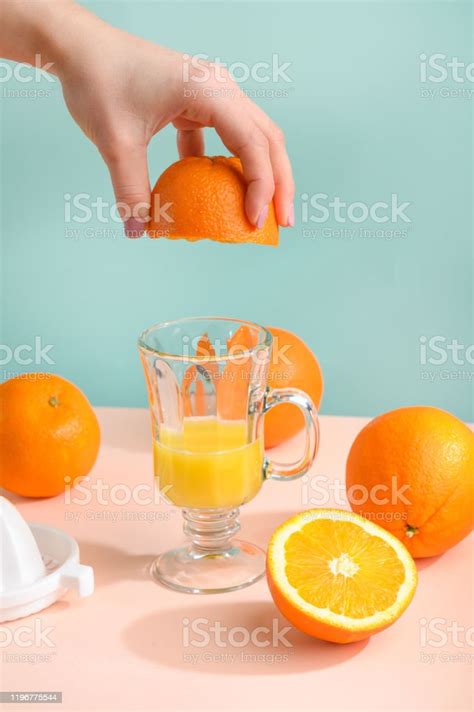 여성의 손에 육즙 신선한 오렌지는 유리 위에 떠있다 밝은 배경에 파스텔 파란색과 오렌지 하드 창조적 인 빛 수직 사진 0명에 대한 스톡 사진 및 기타 이미지 Istock