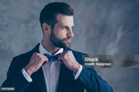 회색 배경 위에 고립 된 블레이저 재킷을 입고 있는 파란색 나비 넥타이를 만지는 마음의 남자의 프로필 측면 갈색 머리에 대한 스톡 사진 및 기타 이미지 Istock