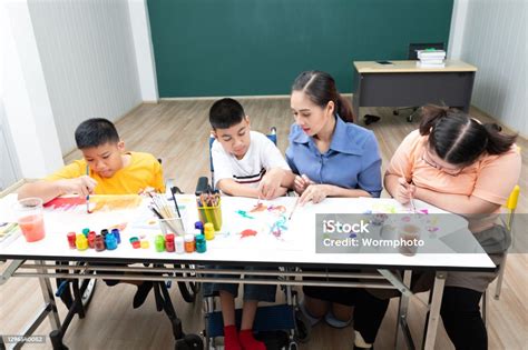 장애아동 또는 자폐아동의 아시아 그룹 교실에서 교사와 함께 종이에 그림을 그리다 자폐증에 대한 스톡 사진 및 기타 이미지