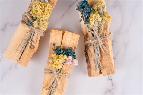 흰색 대리석 테이블 배경 위에 건조한 향기로운 허브로 장식 된 팔로 산토 스틱으로 얼룩 져 있습니다 요가와 명상 연습을위한 방 훈증 의식 플랫 레이 스타일 Mental