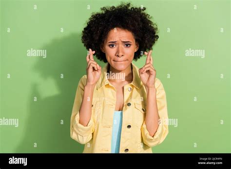 Photo Of Pretty Doubtful Lady Wear Yellow Denim Jacket Fingers Crossed