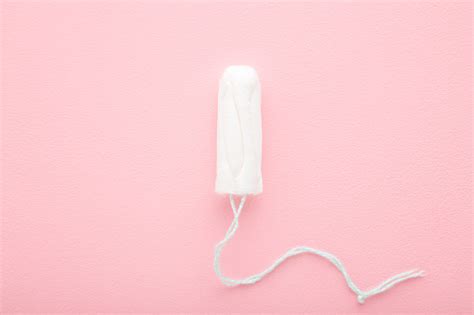 라이트 핑크 테이블 배경에 하나의 새로운 흰색 위생 탐폰 파스텔 색상 근접 촬영 여성 위생 하향 보기 0명에 대한 스톡 사진 및