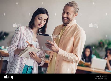 Photo Of Positive Friendly Colleagues Use Tablet Write Notes Notepad