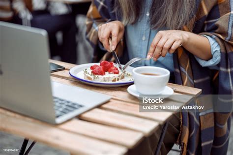 성숙한 여자는 야외 카페 테라스에서 테이블에서 잘라 딸기와 크림토스트를 먹는다 노트북 사용하기에 대한 스톡 사진 및 기타 이미지