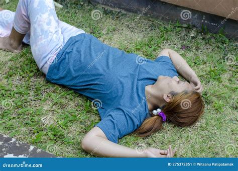 Young Asian Woman Fainting On Grass In Summer Because Outdoors Of Hot
