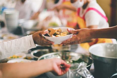 Volunteers Giving Food To Poor People The Concept Of Food Sharing Help