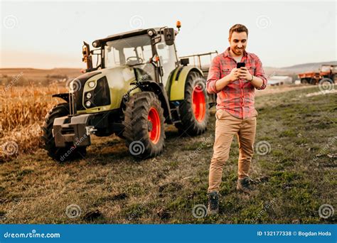 Fazendeiro Masculino Que Trabalha No Campo Usando O Smartphone Na