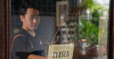 아시아 남자 커피 숍 바리 스타가 카페 문으로 걸어 가서 매달린 닫힌 간판을 열어 놓습니다 고객에게 레스토랑 서비스를 준비하는 남성 웨이터 중소 기업 소유자 및