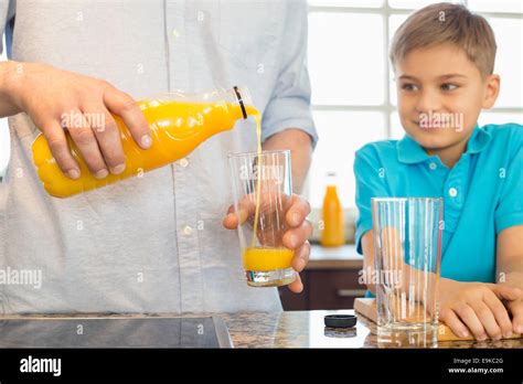 Caring father pouring juice in glass for his beautiful daughter Stock ...