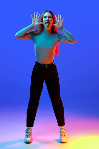 재미 있는 소녀 십대 혼합 네온 불빛 필터의 파란색 배경에 대해 입을 넓게 벌리고 찡그린 학생의 전체 길이 초상화 인간 감정의 개념 놀라움에 대한 스톡 사진 및 기타 이미지