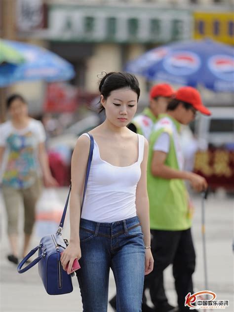 街拍的白色吊带低胸牛仔裤美女 中国娱乐资讯网cecetcn