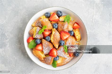 카이저슈만 신선한 베리와 가루 설탕을 회색 콘크리트 배경에 얹은 전통적인 오스트리아 팬케이크 디저트 달콤한 아침 식사 공간을