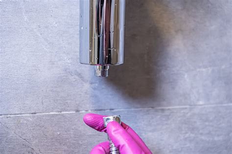 분홍색 장갑을 끼고 더 건강한 피부와 모발을 위한 새로운 샤워 정수 필터를 설치하고 가정 배관 유지 관리 및 복사 공간이 있는 깨끗한 목욕 솔루션을 강조합니다 Diy에 대한