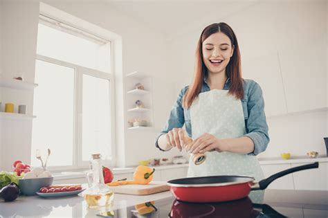 일부 향신료를 추가 하는 전통적인 가족 요리를 만드는 아내 기뻐 하는 과정의 사진 점선 앞치마 밝은 부엌 방 착용 여자에 대한