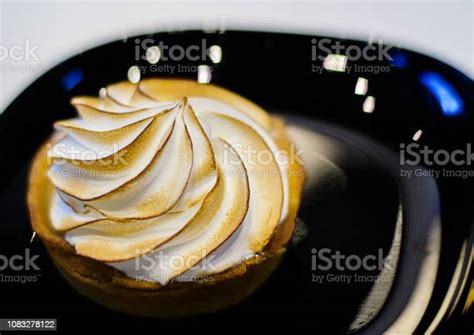 맛 있는 레몬 머 랭 검은 접시에와 Tartlets입니다 빛에 달콤한 치료 평평 하다 고 공간을 복사 합니다 상위 뷰 갈색에