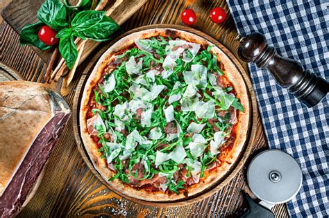 프로 슈 토와 Arugula 집에서 만든 이탈리아 피자에 평면도 토마토와 소박한 배경에 피자 Proscito 바실리 복사 공간