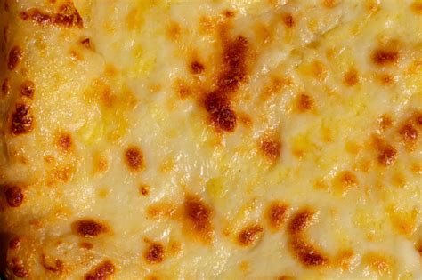 술루구니 치즈와 노른자를 곁들인 아자리안 카차푸리는 바삭해질 때까지 장작불 오븐에서 굽습니다 생과자는 세라믹 타일의 배경에 슬레이트 부분이있는 주석 보드 위에 놓여 있습니다