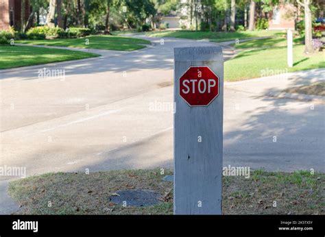 A Neighborhood Intersection With A Caution Sign To Stop For Traffic