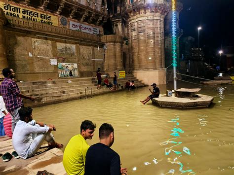 People Sit On The Banks Of Swollen Ganga River Following Heavy Rainfall