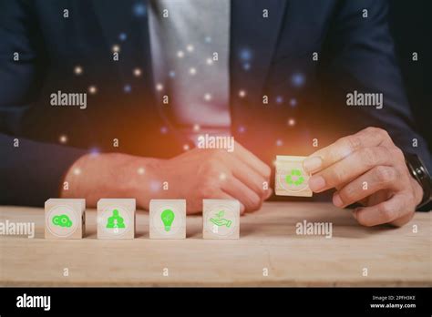 Businessman Lifting Wooden Cube With Recycle Icon Environmental And