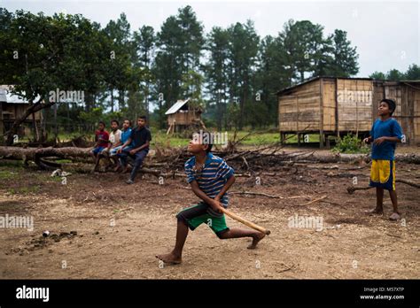 Los niños juegan al béisbol en un campamento de refugiados hondureños