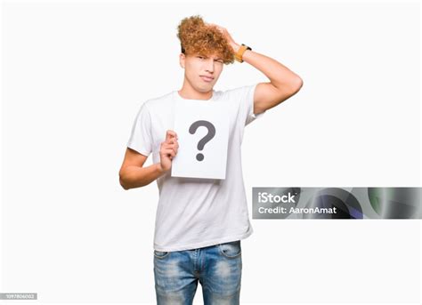 젊은 잘생긴 남자가 머리에 손으로 압박 하는 물음표와 종이 들고 충격 수치심과 깜짝 얼굴로 분노와 좌절 두려워 하 고 실수에 대 한 화가 감정에 대한 스톡 사진 및 기타