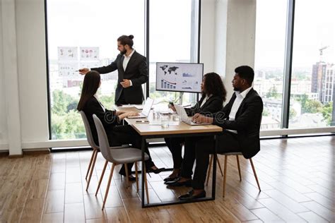 Business Man Giving Presentation To Multiracial Team In Modern Office
