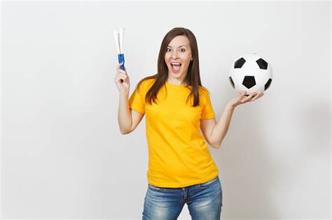 아름 다운 유럽 젊은 쾌활 한 행복 한 여자 축구 팬 또는 노란색 유니폼 축구 파이프 흰색 배경에 고립 된 공을 들고 플레이어