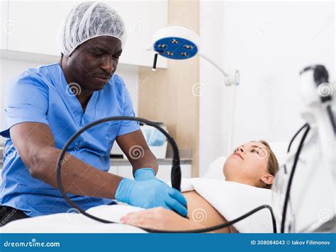 Cosmetologist Performing Ultrasound Cavitation Body Procedure For Woman