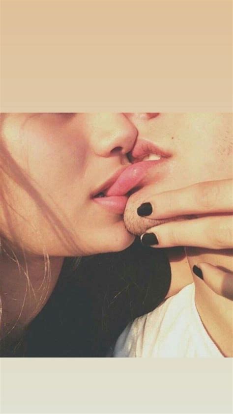 A Man And Woman Kissing Each Other With Their Fingers On Their Lips