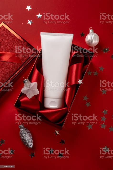 흰색 병 화장품 은 빨간 선물 상자와 빨간색 배경에 뷰티 상품 컨셉의 크리스마스 세일 텍스트가 있는 상단 보기입니다 개체 그룹에