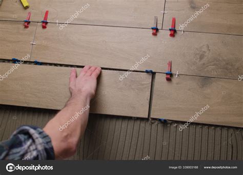 Laying Tile On The Floor Ceramic Tile Laying Pressing Down And Regulating Installing Plastic