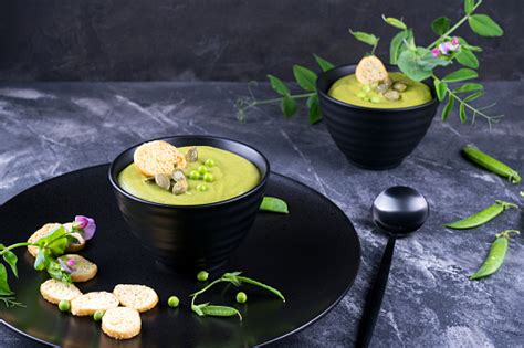 가벼운 여름 맛 있는 완두콩 크림 수프는 호박 씨앗 어두운 배경에 Croutons 함께 제공 됩니다 가벼운에 대한 스톡 사진 및