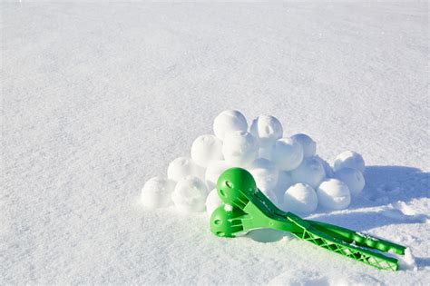 어린이 장난감은 눈에서 눈덩이를 모델링하기위한 도구입니다 녹색 플라스틱 장치 겨울 야외 어린이 게임 활동적인 레저 기프트 눈 덮인 배경 공간을 복사합니다 기치 얼음 집게