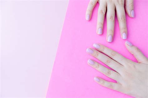 여자에 대 한 핑크 손톱을 닫습니다 세련 된 최신 유행 여성 손톱 매니큐어 핑크와 파란색 바탕에 아름 다운 젊은 여자의 손 상위 뷰 평평 하다입니다 텍스트 복사 공간 감정에