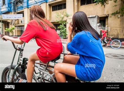 Two Local Filipino Girls Cross The Busy Junction At The Filipino