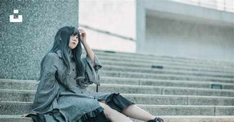 Foto Mujer Con Camisa Gris De Manga Larga Y Falda Negra Sentada En