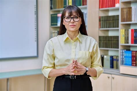 Portrait Of Confident Elegant Mature Business Woman In Library Stock