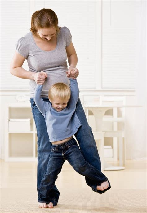 La Madre Embarazada Baila Con Su Hijo En Sus Pies Imagen De Archivo