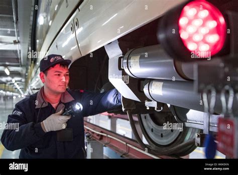 A Chinese Worker Checks A Crh China Railway High Speed Bullet Train