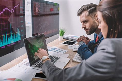 View Of Computer Systems Analysts Using Charts On Computer Monitors