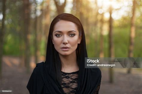 복사 공간 소프트 포커스와 함께 녹색 자연 배경 위에 검은 스카프 전통적인 이슬람 옷 최신 유행 디자인 세련 된 여성 초상화를 입고 아름 다운 아랍 여자 갈색 머리에 대한