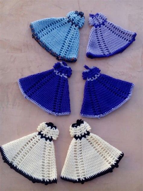 Four Crocheted Blue And White Dresses Are Arranged On The Floor With