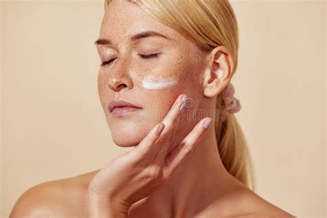 Beautiful Young Female With Closed Eyes Applying White Cream Stock
