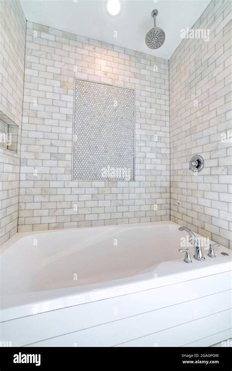 Alcove Bathtub With Marble Subway Tile Surround And Shower Head Stock