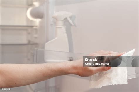 집 청소냉장고 빨 래 세제 병 스프레이 가 정부는 마른 냅킨을 가진 깨끗 한 냉장고의 선반을 정리합니다 젊은 여자 청소 냉장고입니다 가사 집안일에 대한 스톡 사진 및 기타