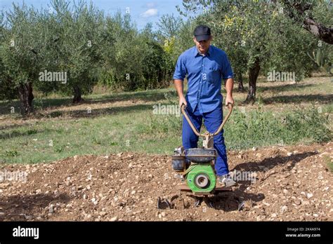 Image Of A Farmer Who With A Hand Tiller Prepares The Land To Cultivate