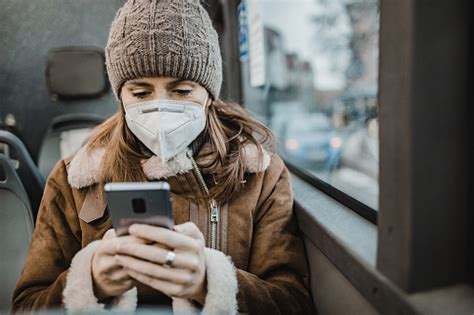 얼굴 마스크를 가진 여성이 대중 교통에서 휴대 전화를 사용하고 있습니다 30 34세에 대한 스톡 사진 및 기타 이미지 30