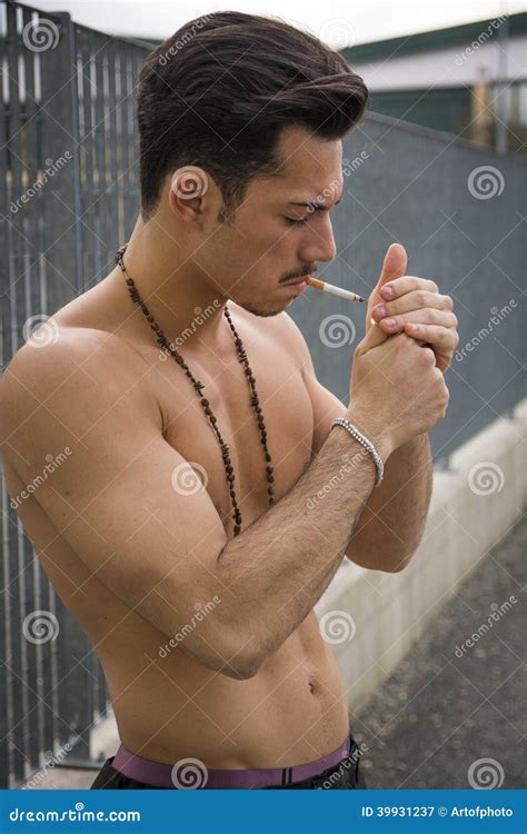 Athletic Shirtless Young Man With Necklace Smoking A Cigarette Stock